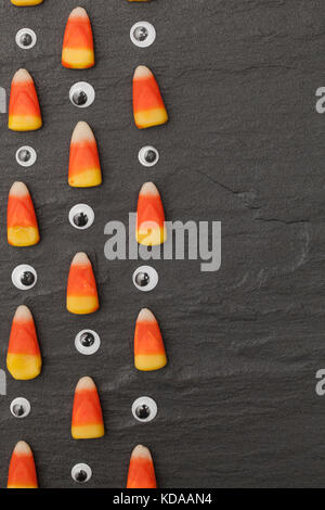 Halloween candy corn sweets and googly eyes background Stock Photo - Alamy