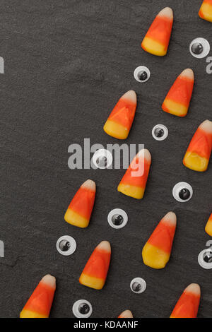 Halloween candy corn sweets and googly eyes background Stock Photo - Alamy