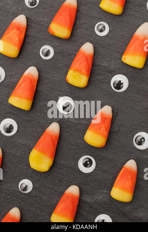 Halloween candy corn sweets and googly eyes background Stock Photo - Alamy