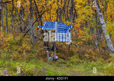 Sign poles by the side of a Navvy Road Trail. Colorful trees, forest in ...