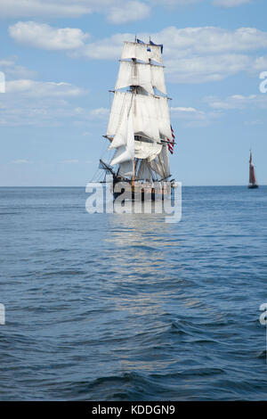 A tall ship known as a brigantine sails on blue water Stock Photo - Alamy