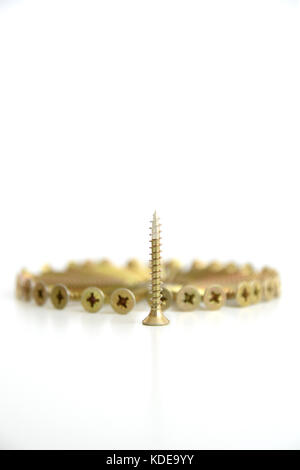 Circle of brass screws on white background with one odd man out Stock ...