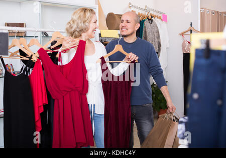 Happy couple choosing new fancy dress in clothing store Stock Photo - Alamy