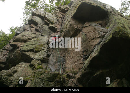 A rock climber makes an ascent of the Dewerstone, in Dartmoor Stock ...