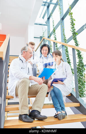 Team of doctors discuss therapy in hospital hallway Stock Photo - Alamy
