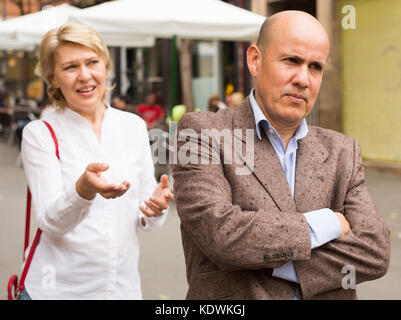closeup of angry retiree man being sad with woman standing outdoors ...