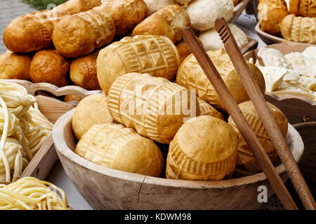Many kinds of oscypek smoked cheese next to korbacik cheese on white ...