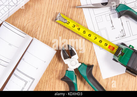 Rolls of electrical diagrams with work tools lying on construction ...