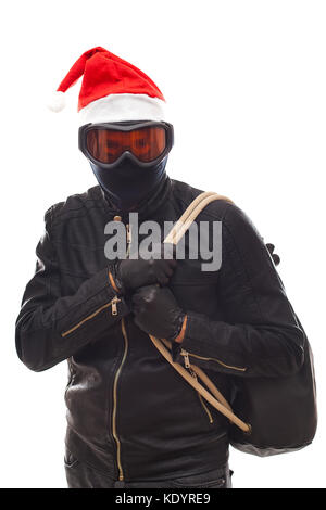 Masked burglar with santa claus cap holding his sack, posing on ...