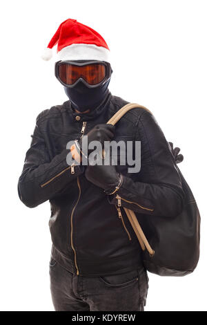 Masked burglar with santa claus cap holding his sack, posing on ...