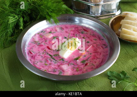 Summer cold beetroot soup with sour cream and egg on white tile ...