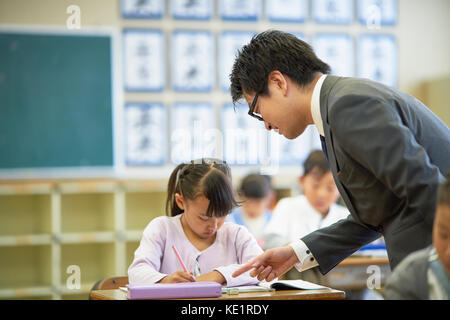 Japanese elementary school teacher teaching in the classroom Stock ...