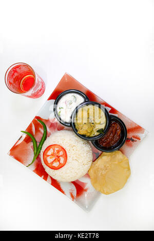 Indian Gee rice with complete curry meal served on a tray in a ...