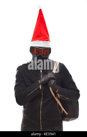 Masked burglar with santa claus cap holding his sack, posing on ...