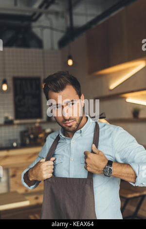 Young handsome man wearing apron holding toilet brush smiling happy and ...