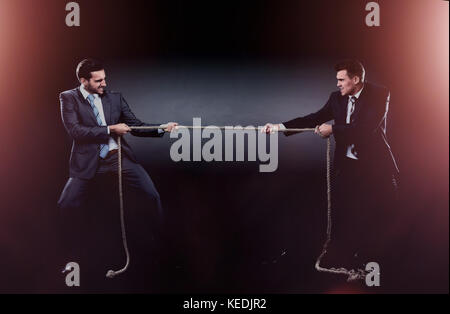 Two business men pulling rope in a competition Stock Photo - Alamy