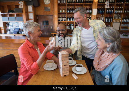 happy friends playing jenga game, focus on foreground Stock Photo - Alamy