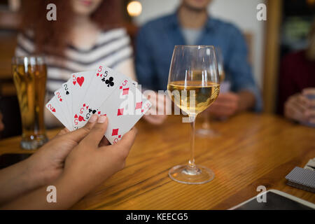 Mid section of friends playing cards in bar Stock Photo - Alamy