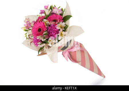 carnation and gerbera in a paper bouquet tied ribbon on a white ...