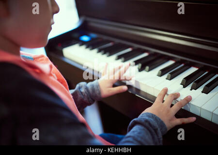 Over the shoulder view of a boy practicing playing classical violin ...