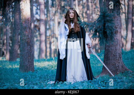 Young woman with sword, princess dress and alien ears stands in a rose ...