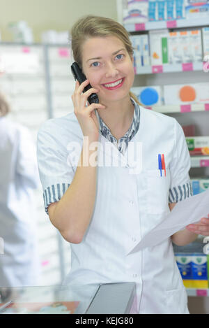 Phone call, pharmacist and woman reading medicine information for stock ...