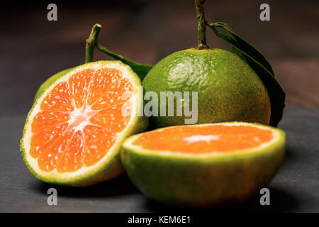 green Mandarin slices on black background Stock Photo - Alamy