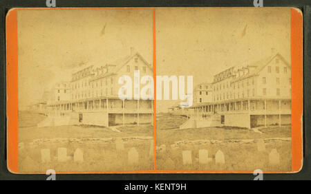 A photograph of large beach houses with headstones in the foreground ...