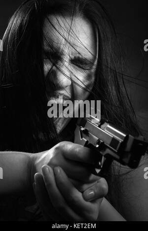 screaming young woman with gun aiming on red background Stock Photo ...