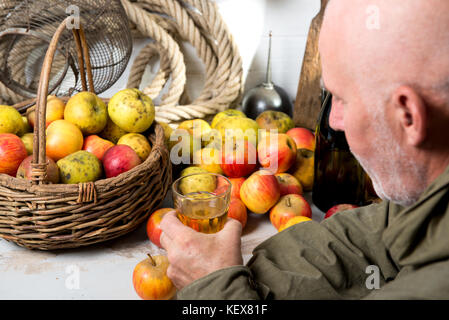 man with a bottle and glass of cider, apples at background Stock Photo ...