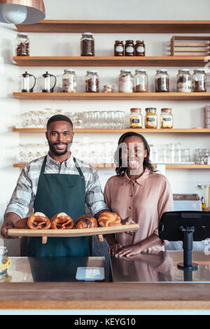 Business owners behind the counter at their cafe, close up Stock Photo ...
