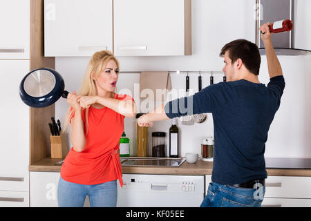 Couple Hitting At Each Other In Kitchen Stock Photo - Alamy