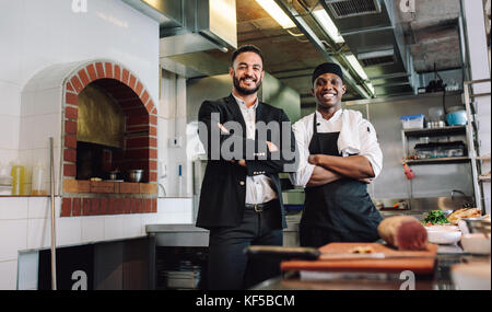 restaurant manager and his staff in kitchen. interacting to head chef ...
