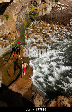 Surfer walking on cliffs along the Pacific Ocean at Sunset Cliffs ...
