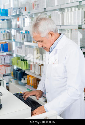 Young caucasian man pharmacist using touchpad working at pharmacy Stock ...