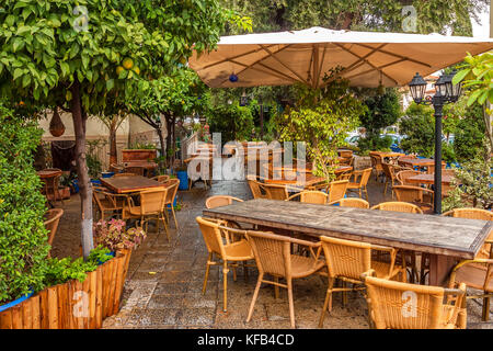 Closeup of empty European cafe wooden table and chair with bokeh ...