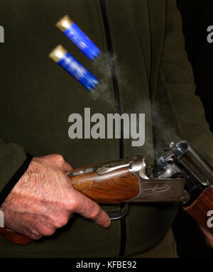 Break-action shotgun in the moment of ejecting empty shells Stock Photo ...
