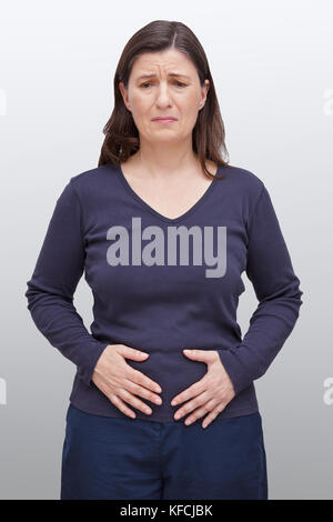 Woman with a pained expression on her face and her hands on her head ...