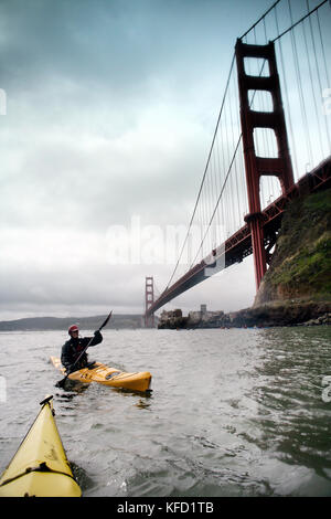 USA, California, San Francisco, individuals endure the cold to kayak ...