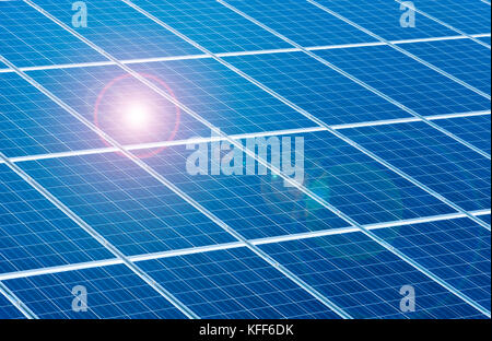 Solar panels with red sun reflection and strong Sun flares. Renewable ...