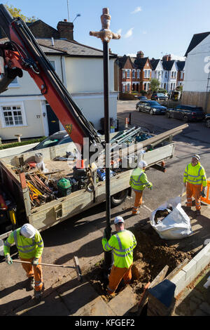Team of lighting contractors fitting a Heritage street lamp / street ...