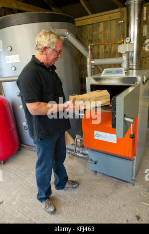 Chris Chilcott with his wood burning boiler at his home in Cornwall ...
