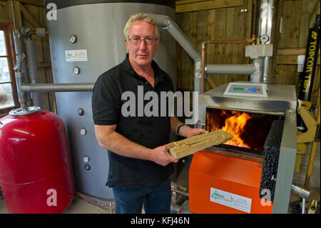 Chris Chilcott with his wood burning boiler at his home in Cornwall ...