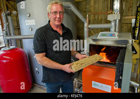 Chris Chilcott with his wood burning boiler at his home in Cornwall ...