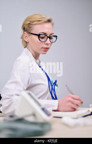 The doctor makes notes in the diary Stock Photo - Alamy