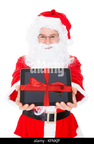 Tablet on Christmas background with santa hat and gift box. New Year ...