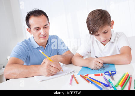Father and child drawing together with colorful markers, sharing a ...