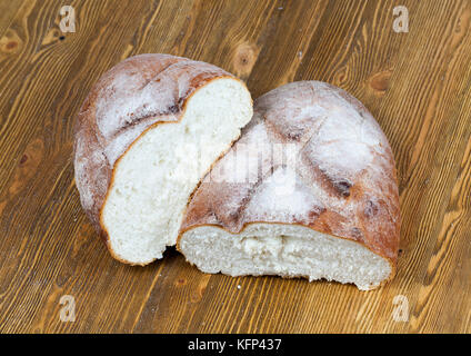 Two halves of a loaf of rustic bread with a knife between them Stock ...