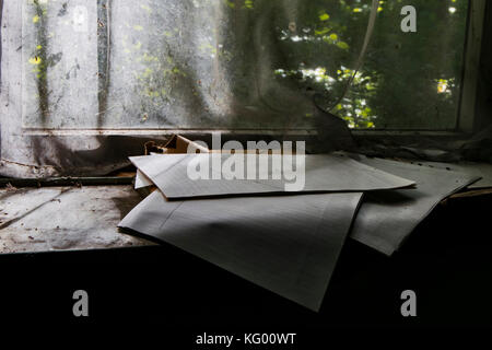 some old papers on a the sill of a window inside an abandoned madhouse ...
