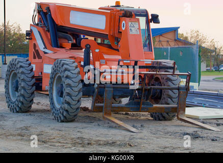 Orange forklift truck by an industrial building Stock Photo - Alamy